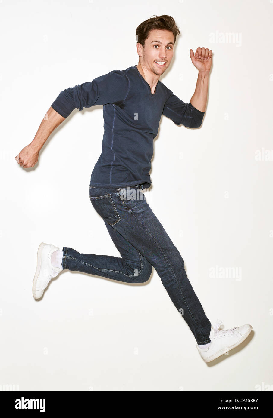 Portrait of man jumping in the air against white background Stock Photo ...
