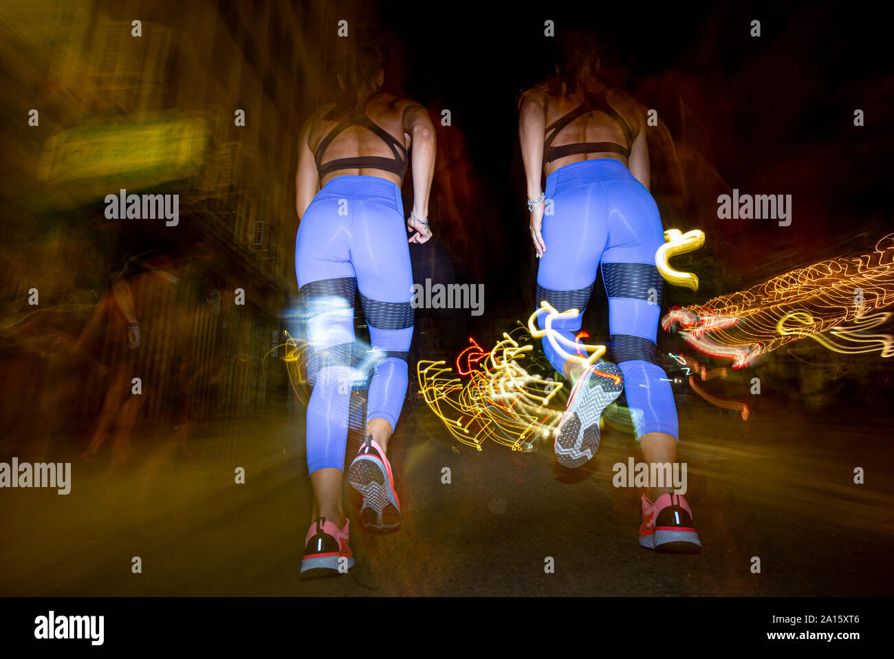 Long exposure photo of two women running in the city at night Stock ...