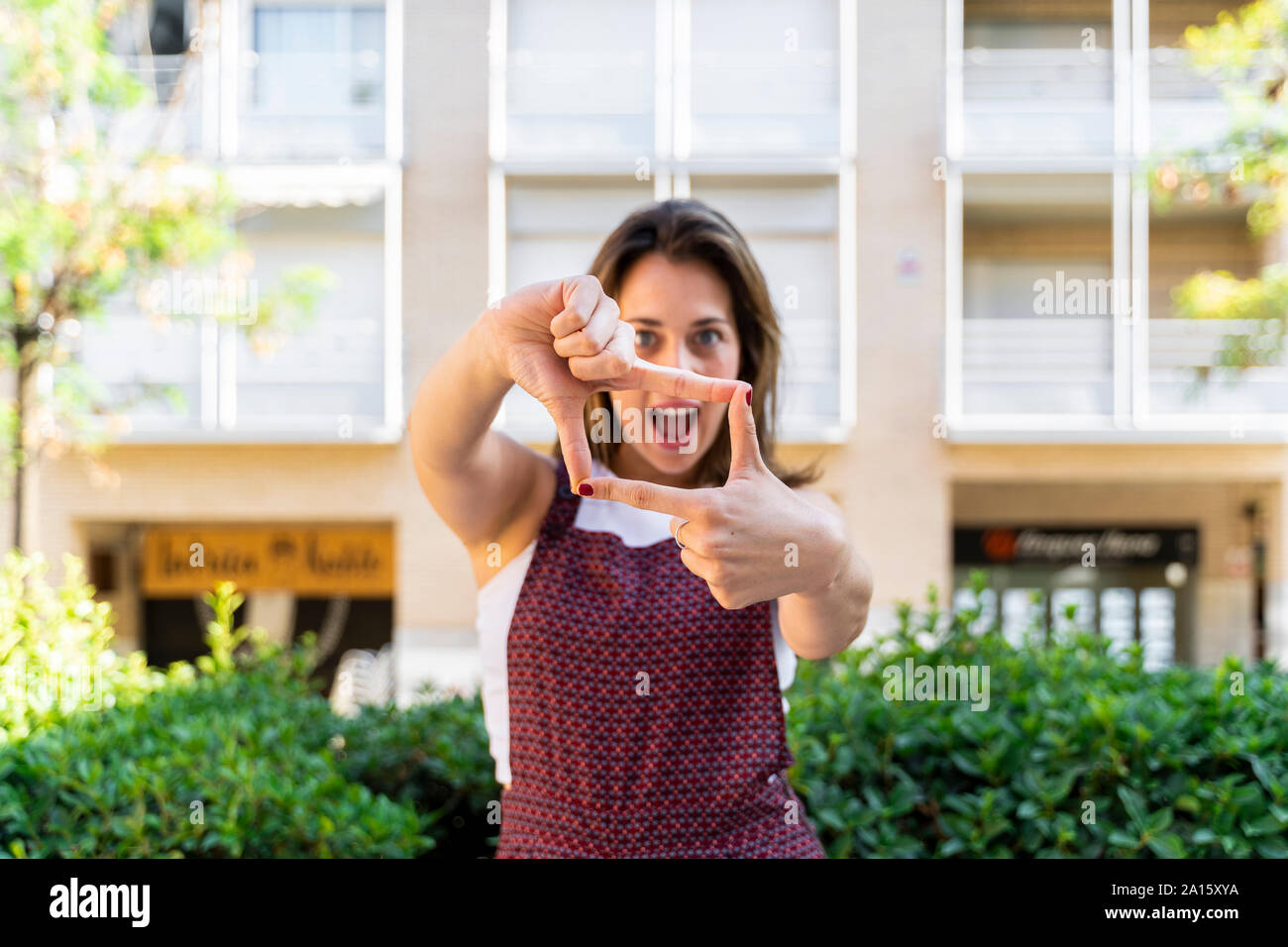 Portrait of young woman making a hand sign for selfie Stock Photo - Alamy