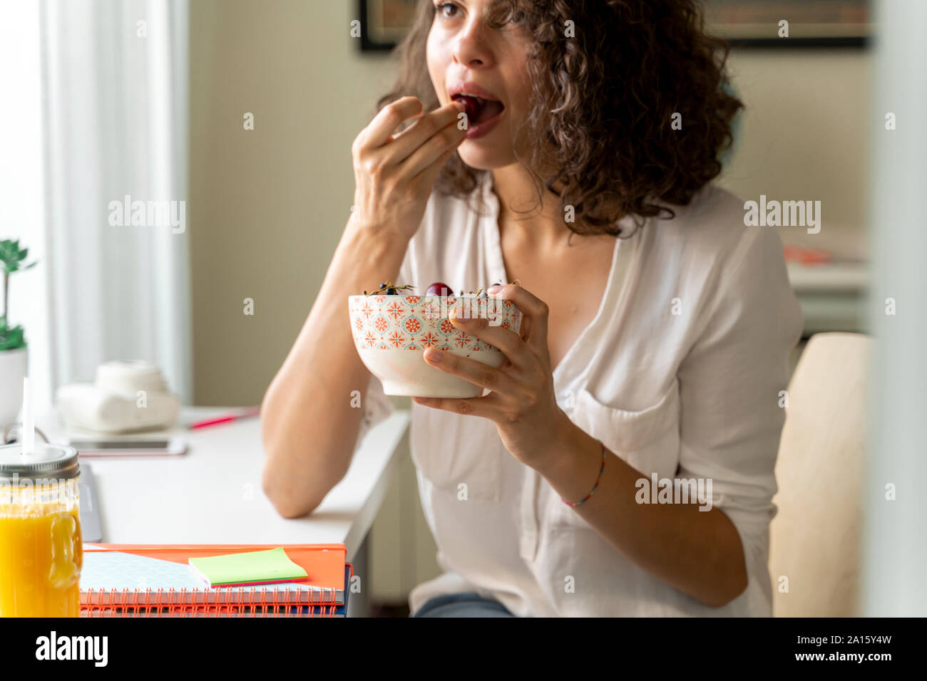 Woman eating at office desk hi-res stock photography and images - Alamy