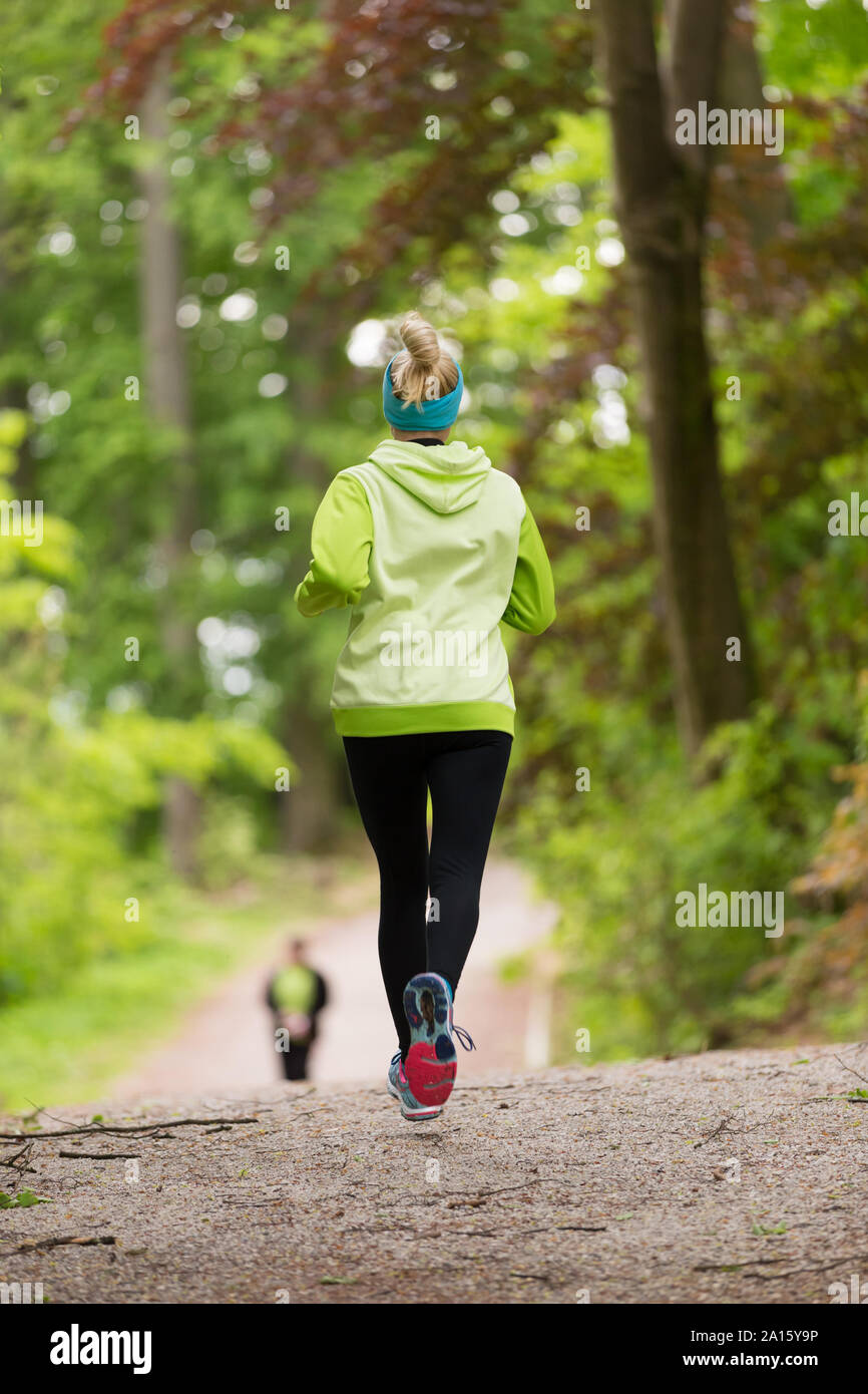 Sporty young female runner in the forest Stock Photo - Alamy