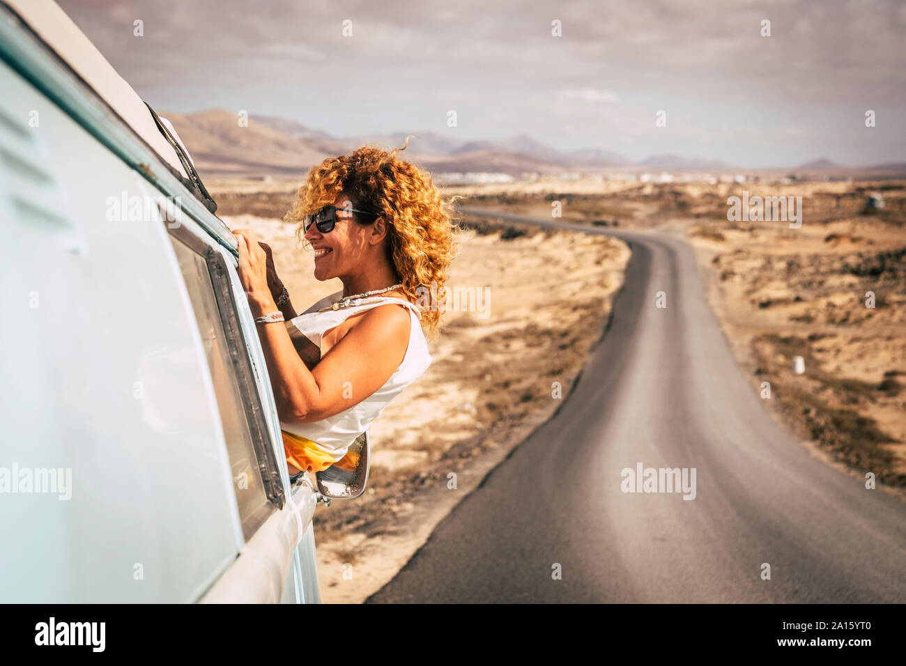 Woman with sunglasses leaning out the window of a van Stock Photo - Alamy