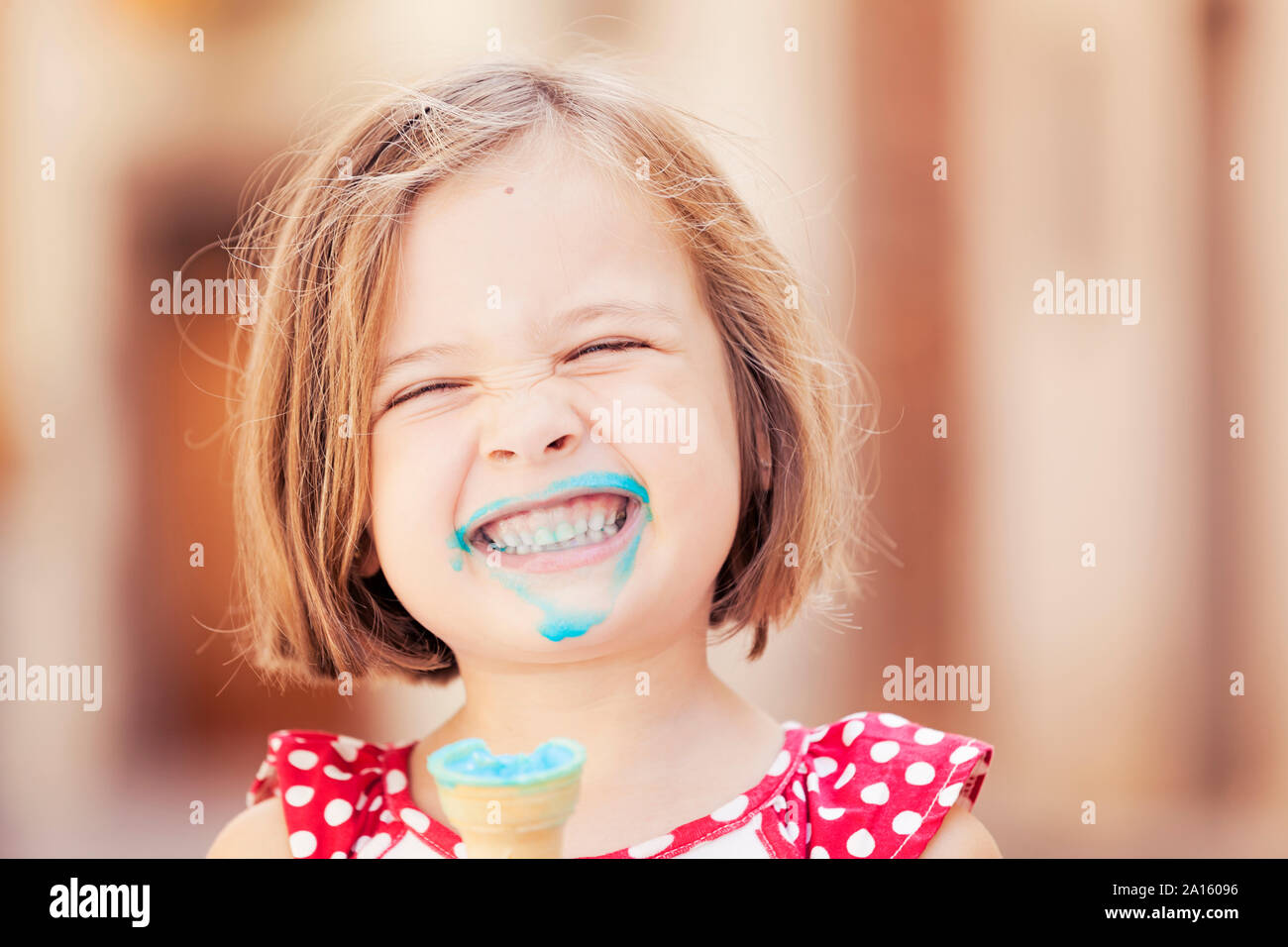 A happy girl eating a blue ice cream Stock Photo - Alamy