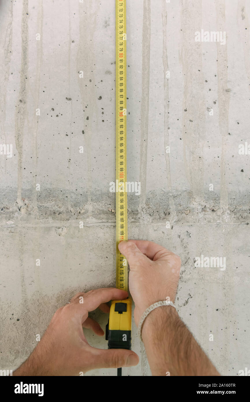 Architect metering a wall at construction site Stock Photo - Alamy
