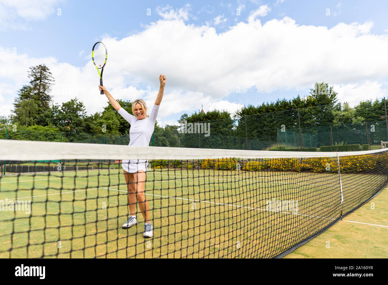 Happy female tennis player celebrating the victory on grass court Stock ...