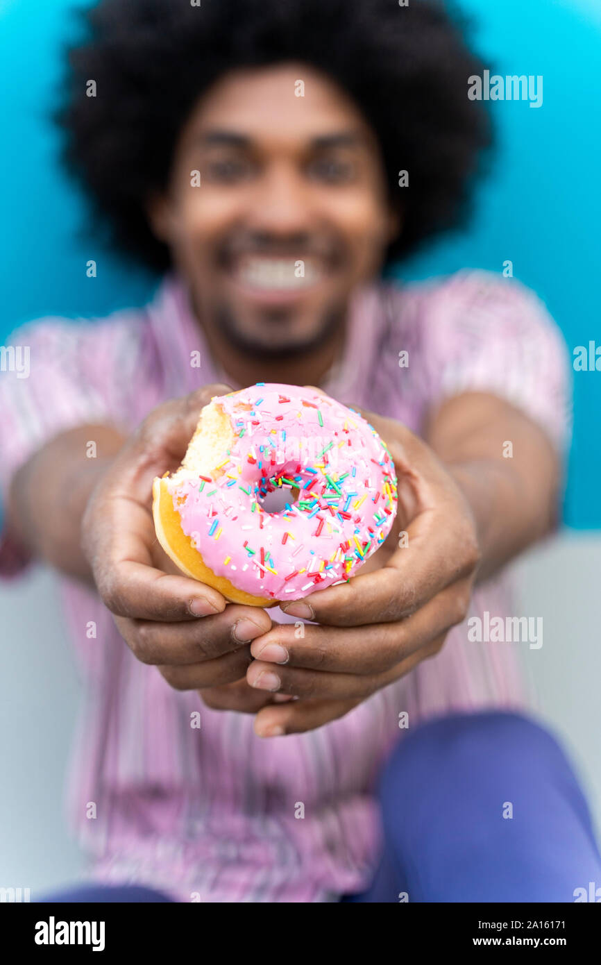 Young man eating donut Stock Photo - Alamy