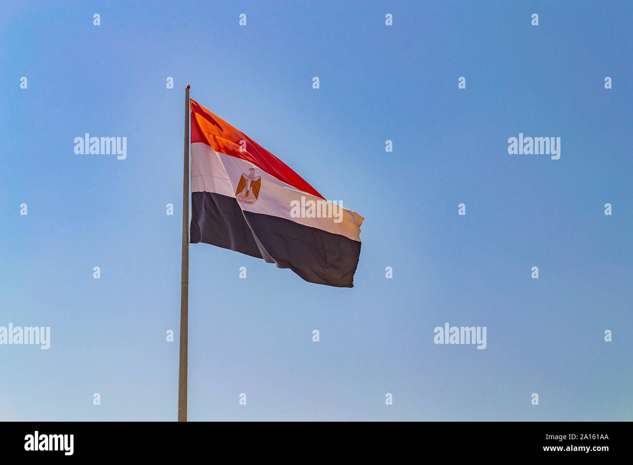 Flag of Egypt on flagpole against clear blue sky. Sharm-el-Sheikh ...
