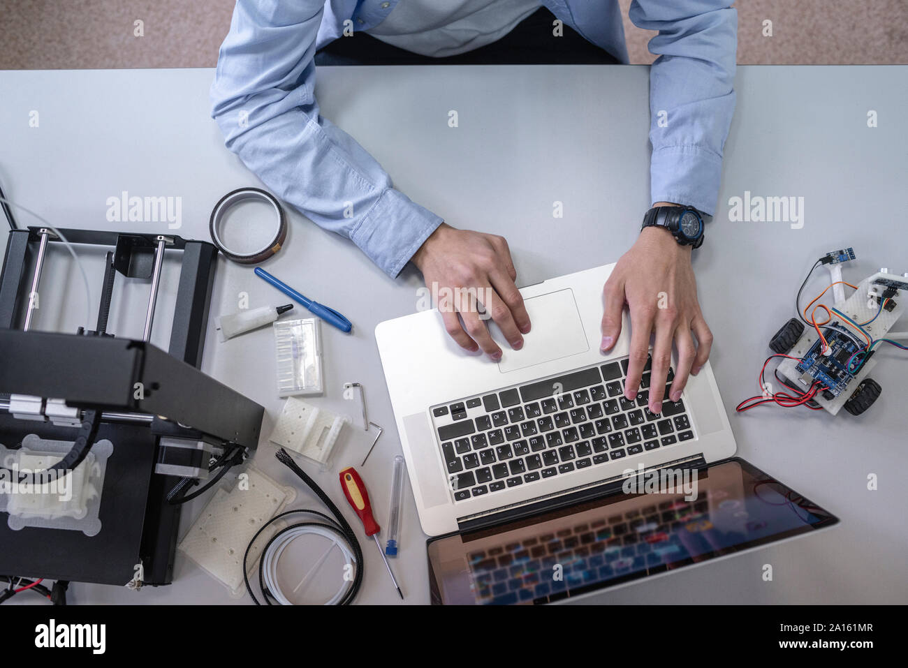 Student setting up 3D printer,using laptop, overhead view Stock Photo ...