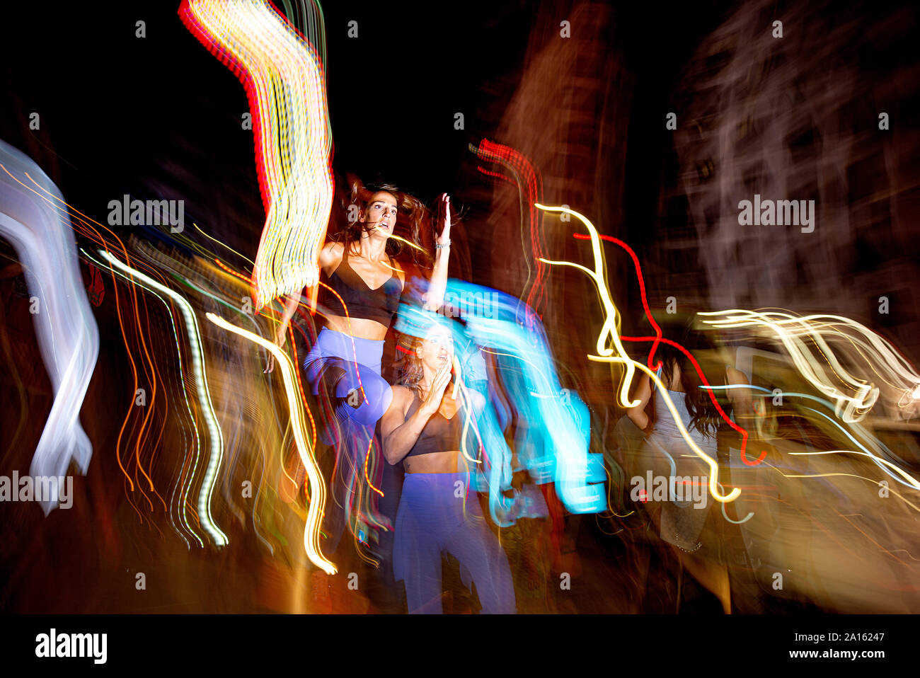 Long exposure photo of two women running in the city at night Stock ...