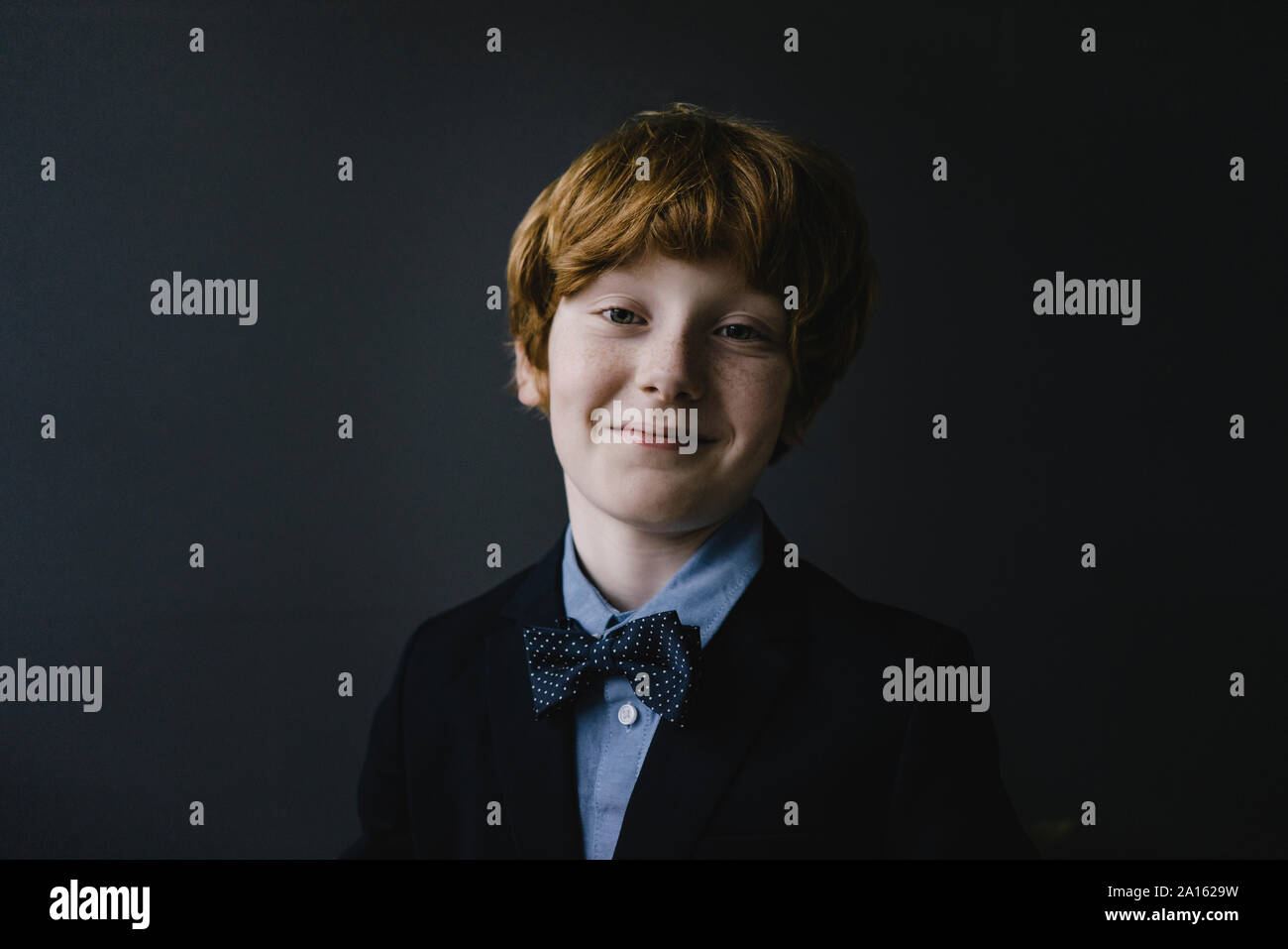 Portrait of smiling redheaded boy wearing bow tie Stock Photo - Alamy