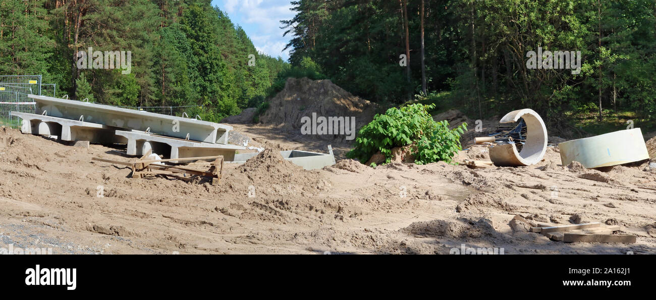 Large concrete beams and pipes heaps of sand with traces of heavy ...