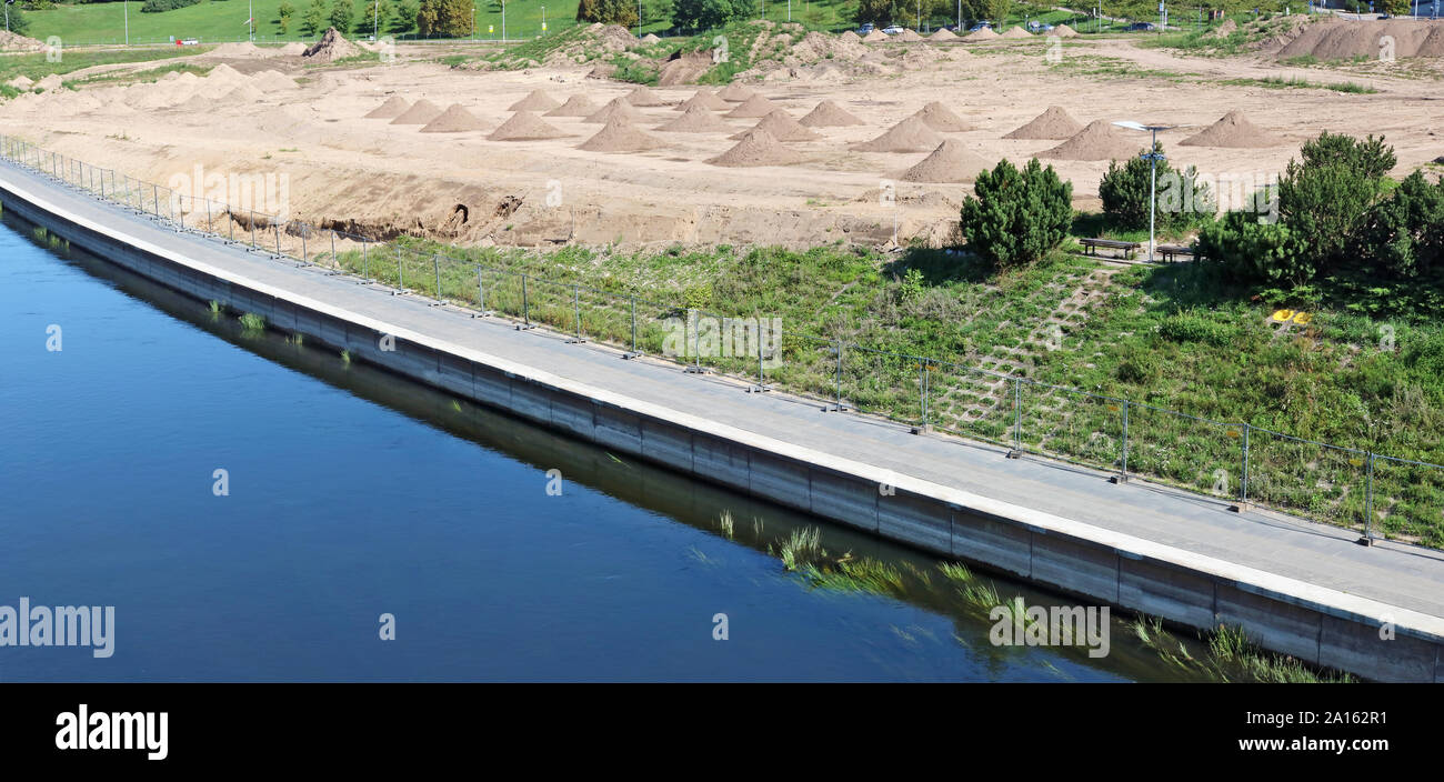 Repair of the old embankment by the river, which flows through the ...