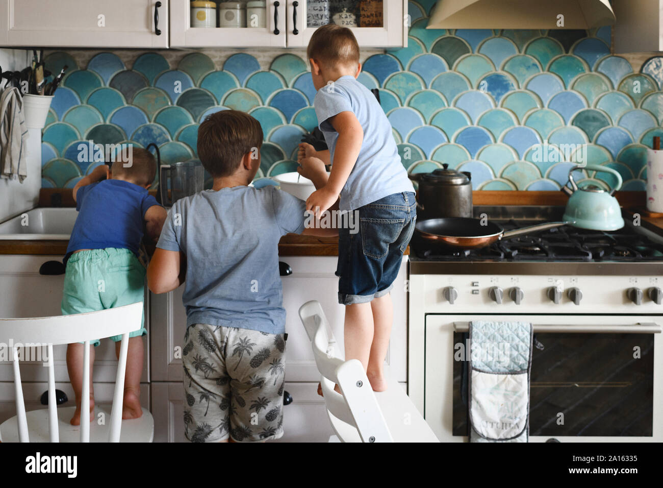 Three brothers cooking pancakes in the kitchen Stock Photo - Alamy