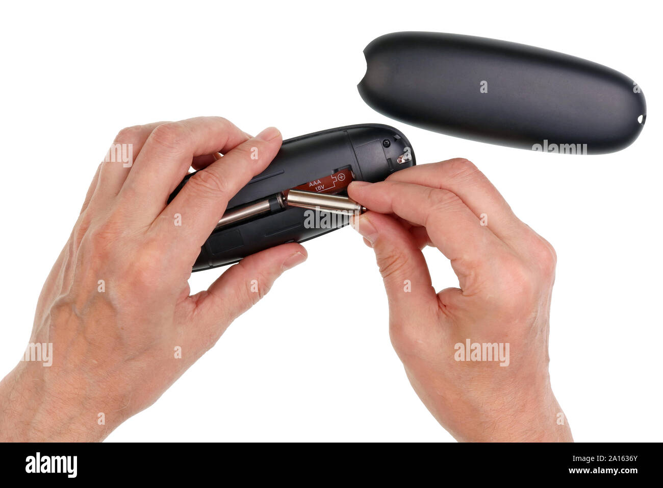 Elderly senior man inserts AAA 1.5V size batteries into a oval shape ...