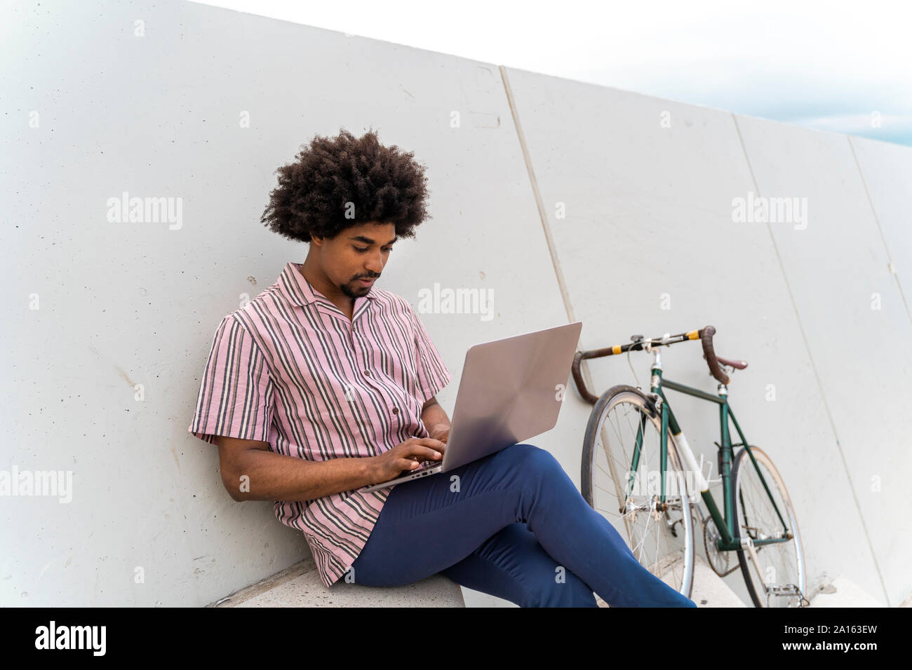Young man sitting on steps hi-res stock photography and images - Alamy
