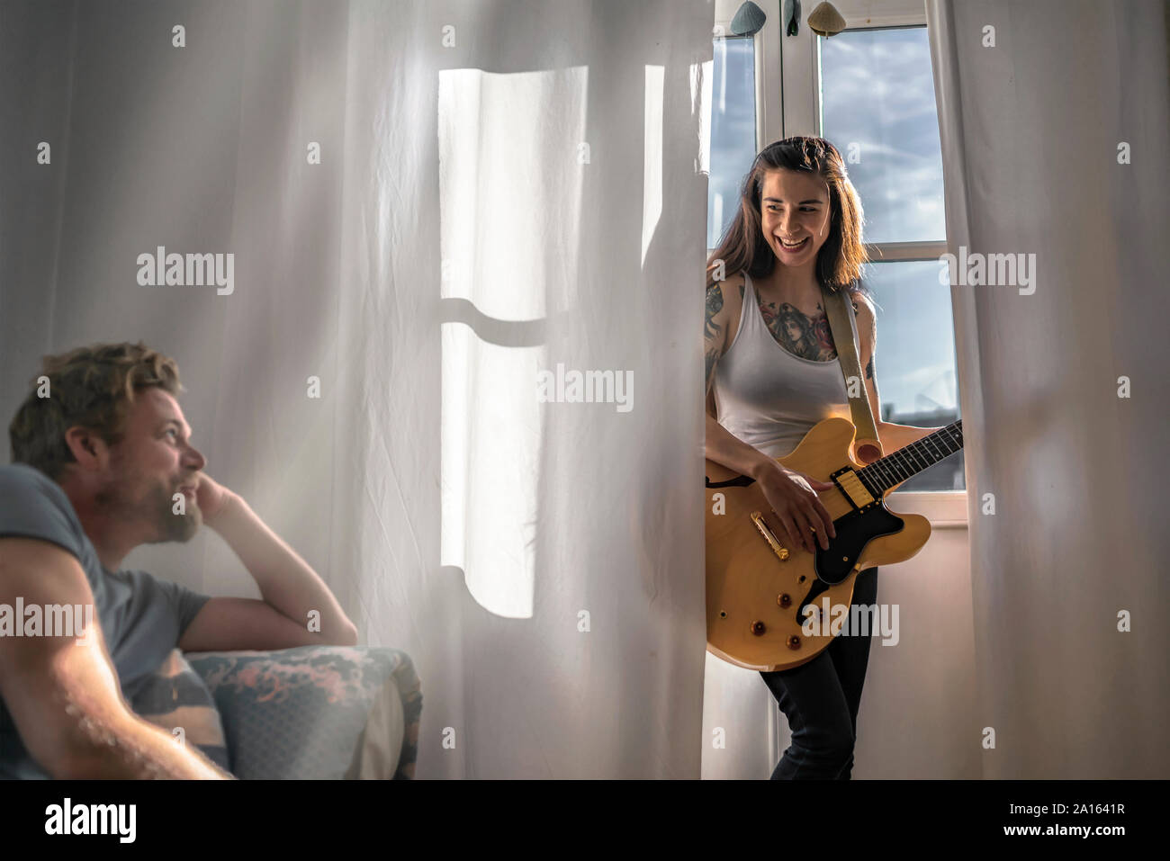 Man looking at young woman at the window at home with a guitar Stock ...
