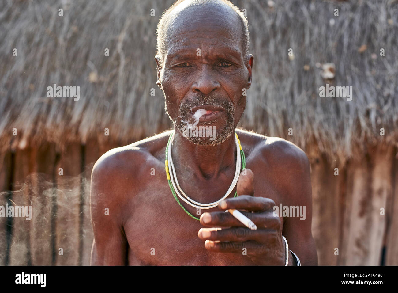 Traditional Mudimba tribe man smoking, Mudimba tribe, Canhimei, Angola ...