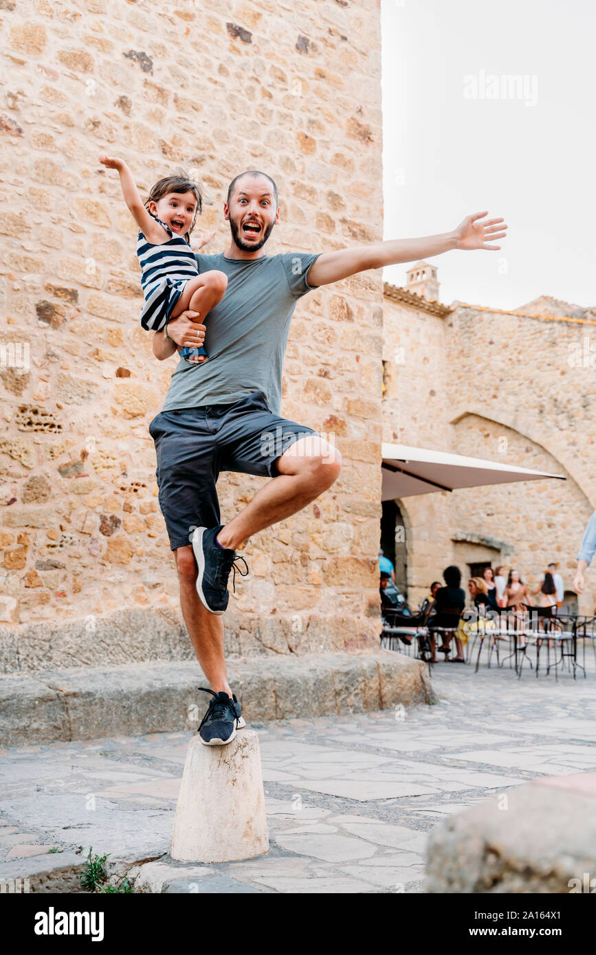 Happy little girl and father having fun while balancing together on a ...