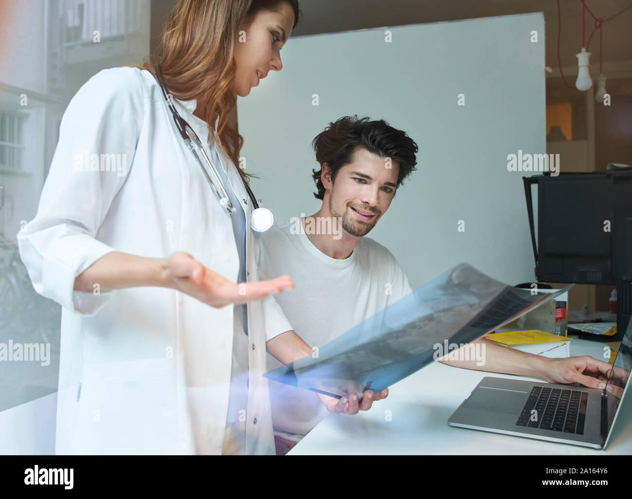 Two doctors discussing x-ray image at desk Stock Photo - Alamy