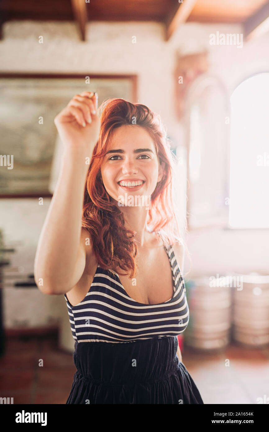Portrait of happy young woman playing darts in a sports bar Stock Photo ...