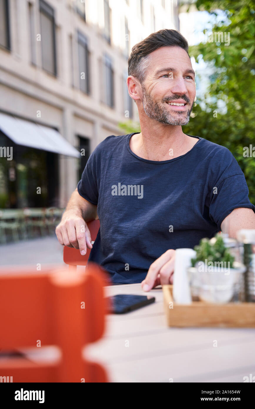 Man sitting by street hi-res stock photography and images - Alamy