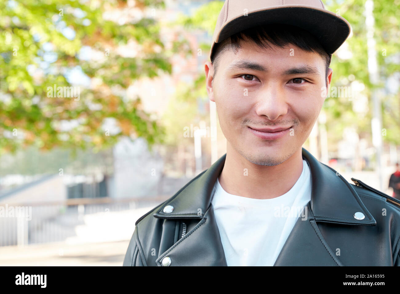Portrait of confident young man wearing leather jacket and cap hi-res ...