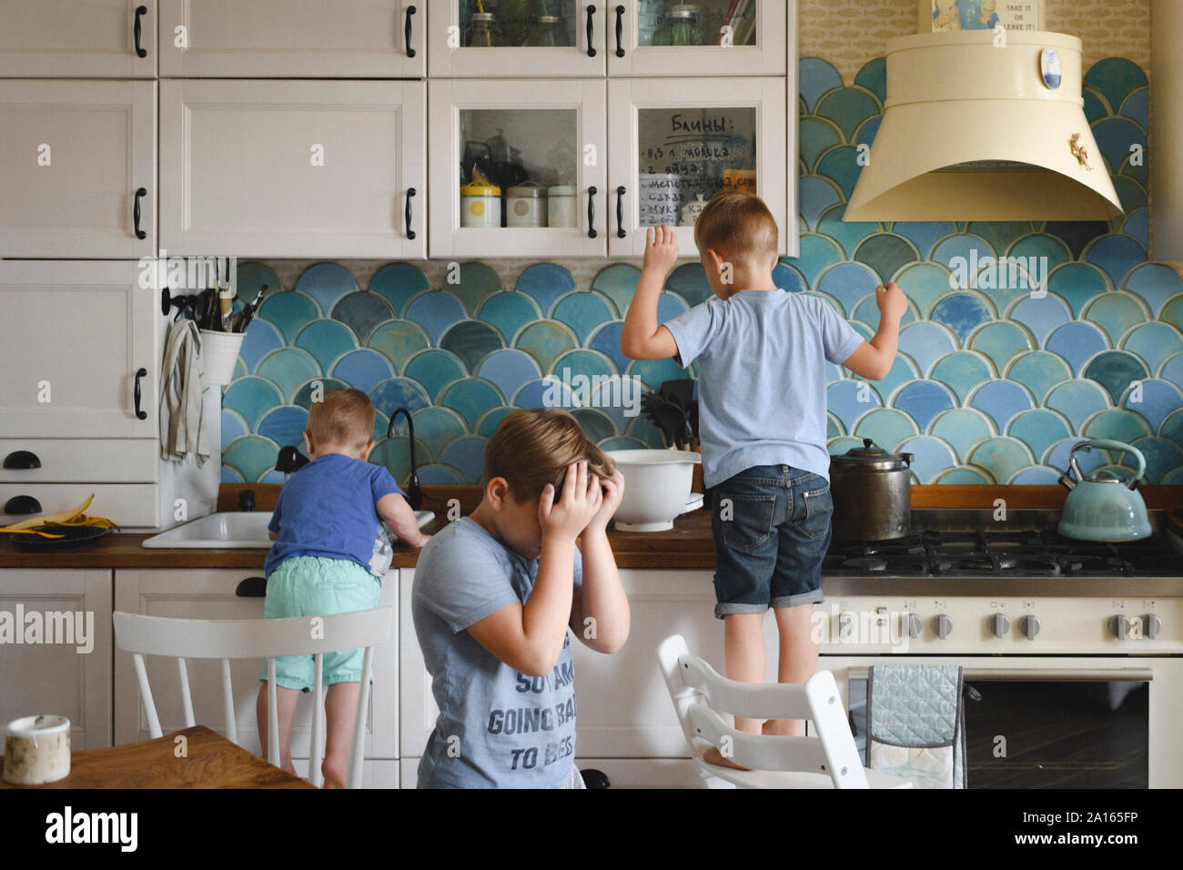 Three brothers cooking pancakes in the kitchen Stock Photo - Alamy