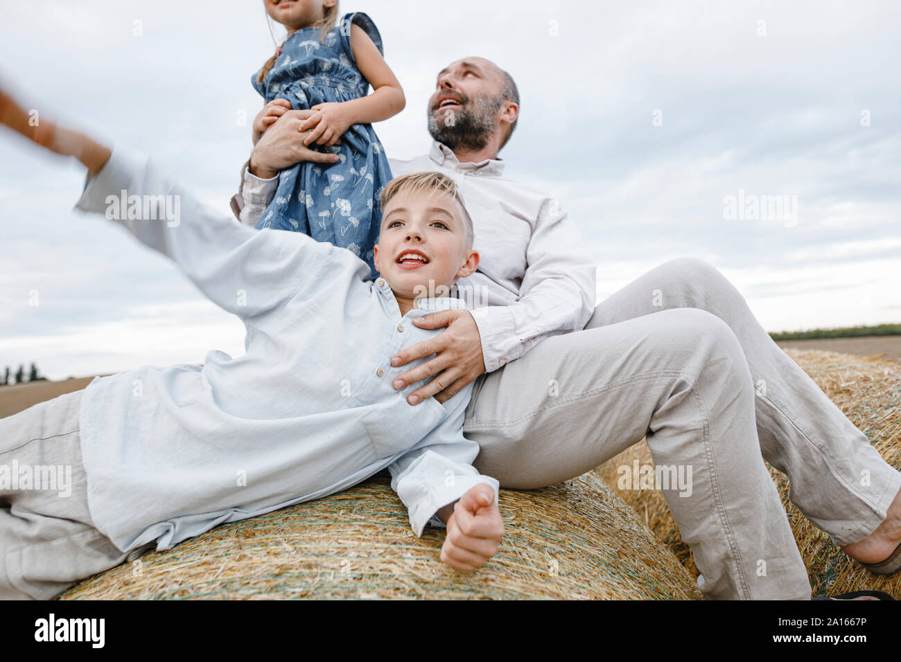 Father and his children playing and laughing on hay bales Stock Photo ...