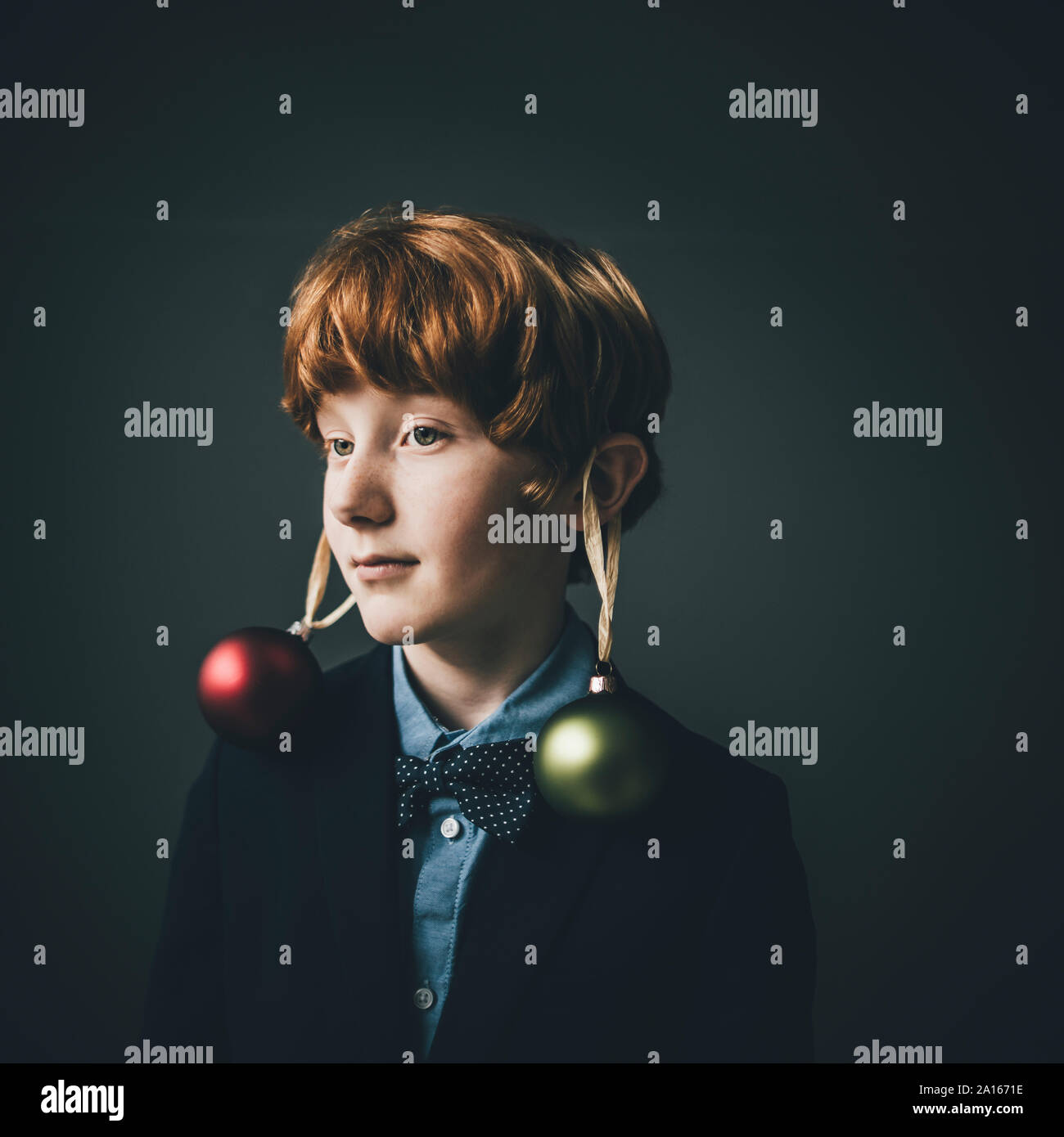 Portrait of redheaded boy wearing bow tie and Christmas baubles Stock ...