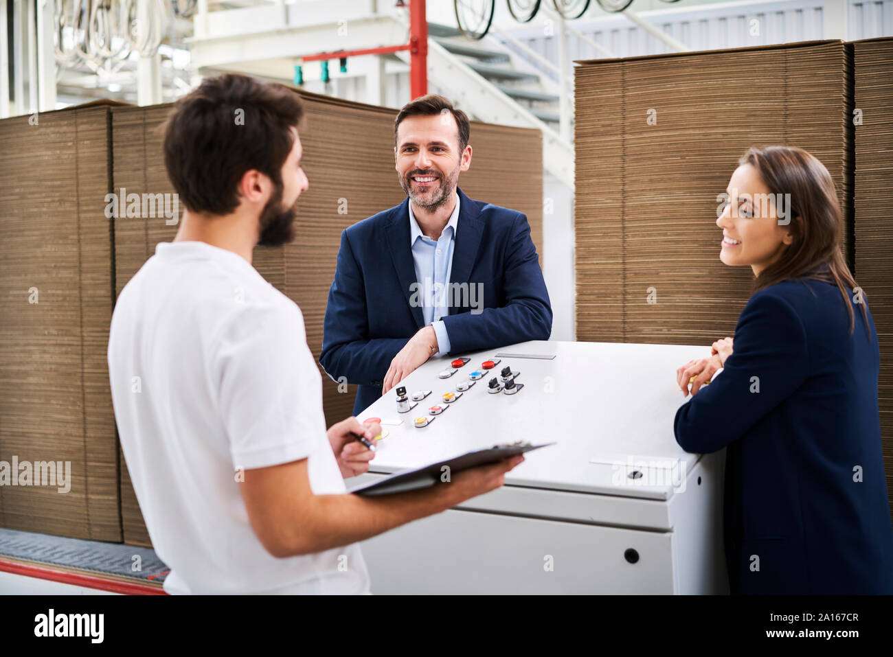 Business people and employee talking in a factory Stock Photo - Alamy