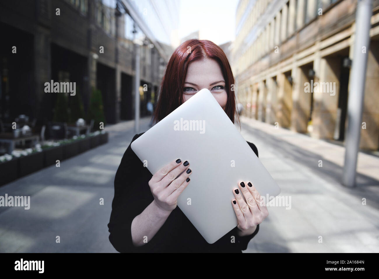 Businesswoman covering face with laptop Stock Photo - Alamy