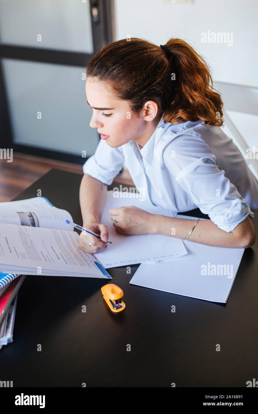 Focused female student learning at desk at home Stock Photo - Alamy