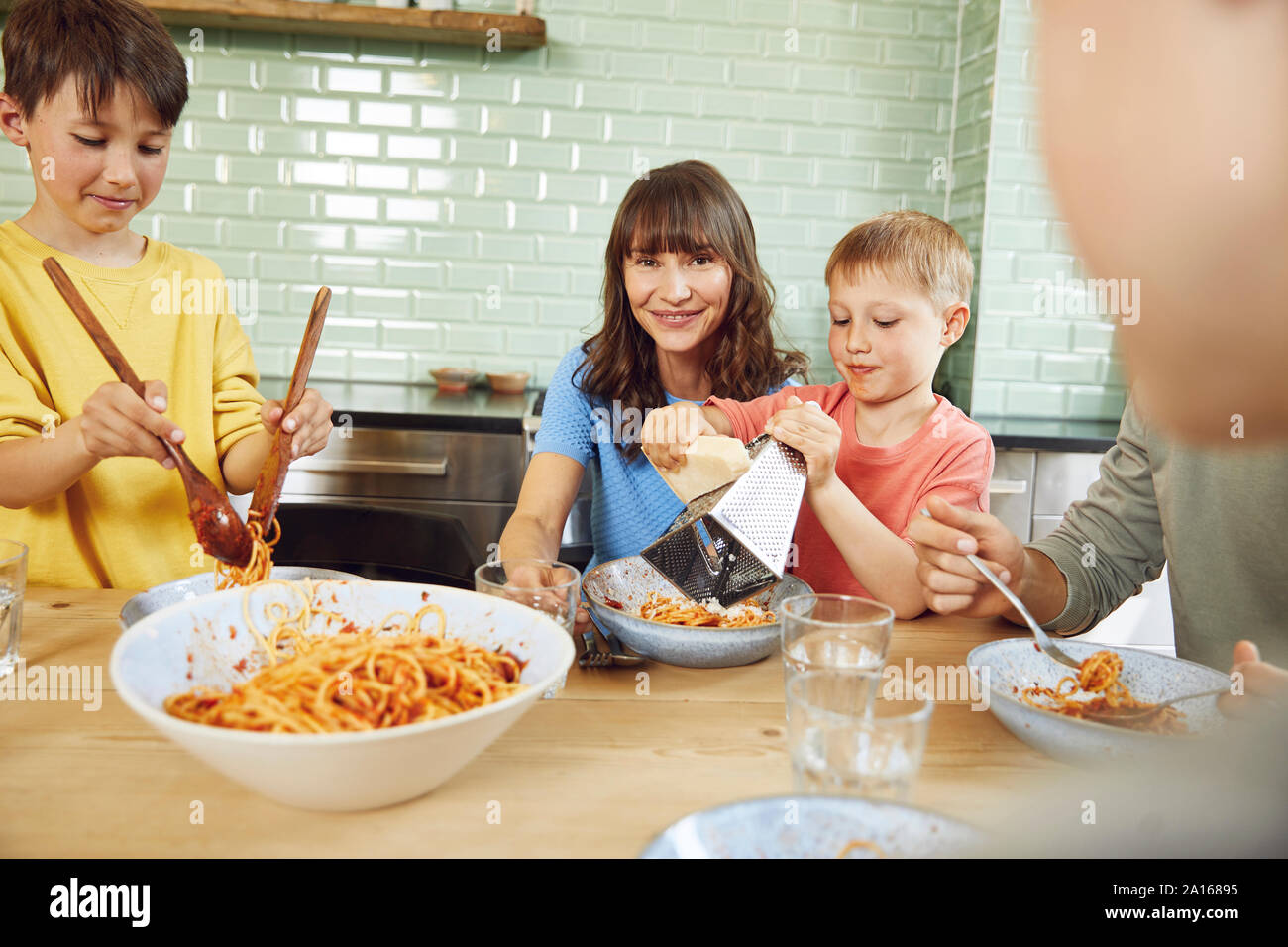 Mother eating spaghetti with her sons in the kitchen Stock Photo - Alamy