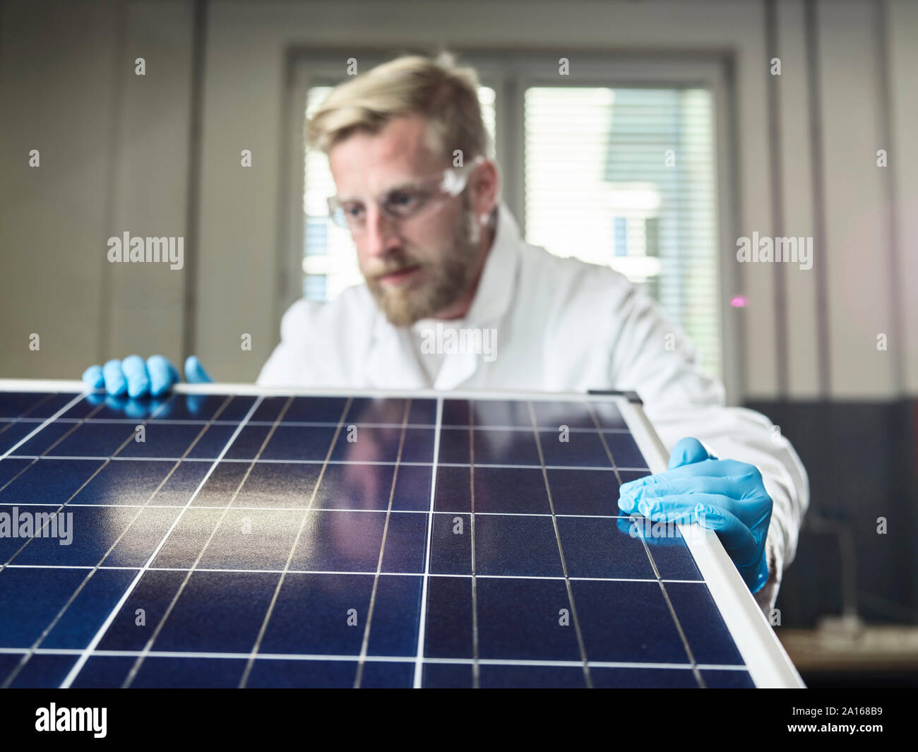 Technician controlling solar panel in lab Stock Photo - Alamy
