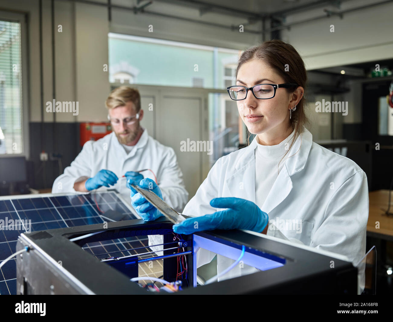 Two technicians working on solar cell in lab Stock Photo - Alamy