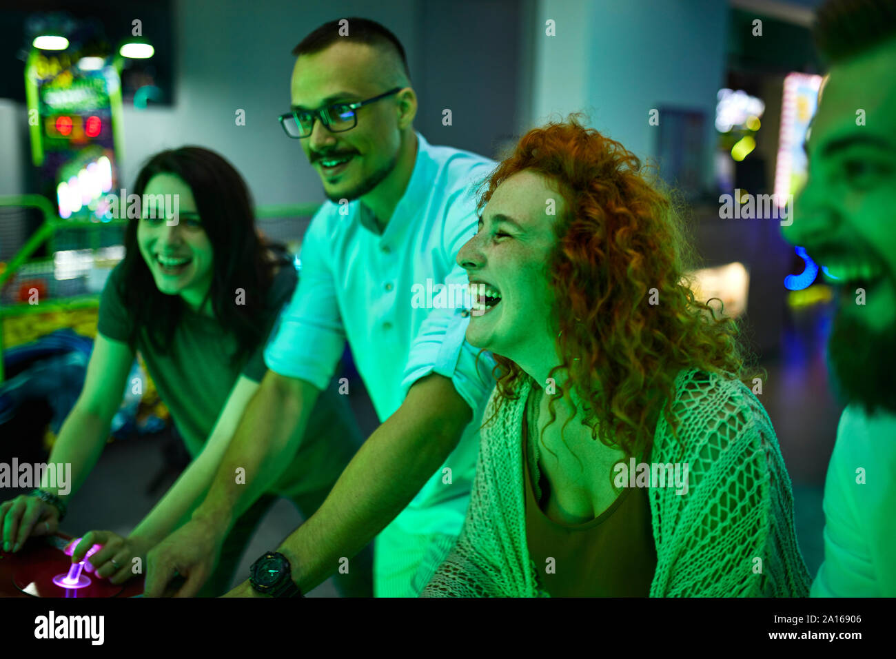 Happy friends playing and having fun in an amusement arcade Stock Photo ...