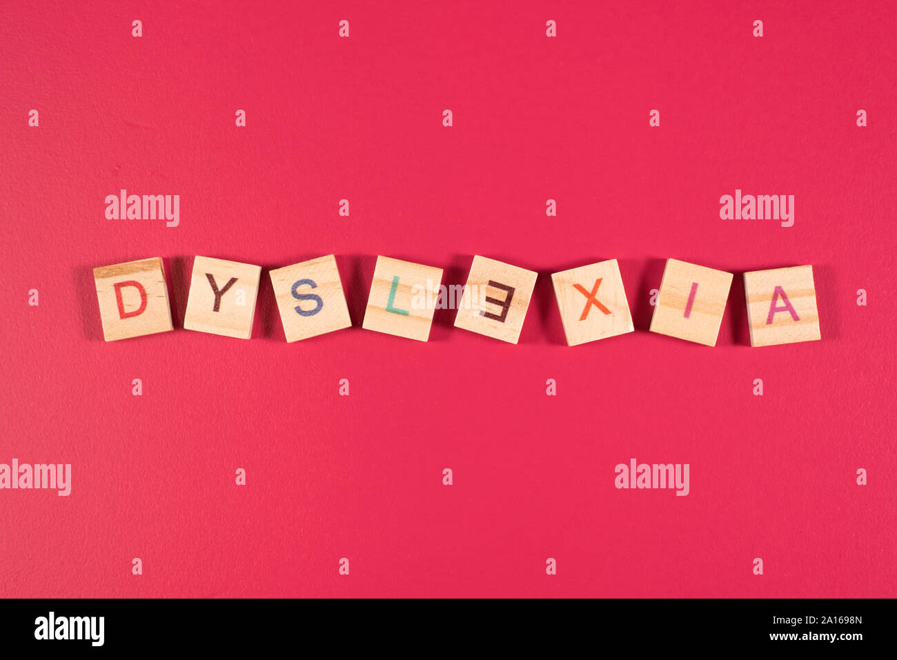wooden alphabet blocks with DYSLEXIA word on pink background. Concept ...