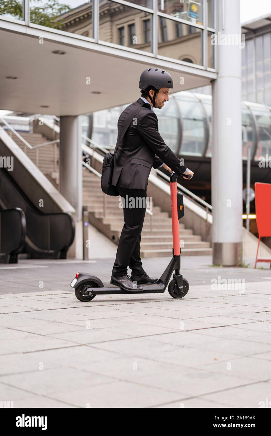 Businessman riding e-scooter in the city Stock Photo - Alamy