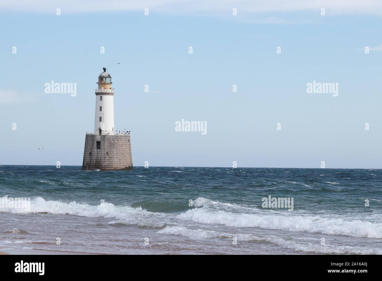 White lighthouse on platform in sea Stock Photo - Alamy