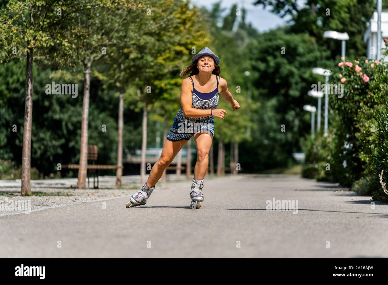 Smiling young woman riding inline skates Stock Photo - Alamy