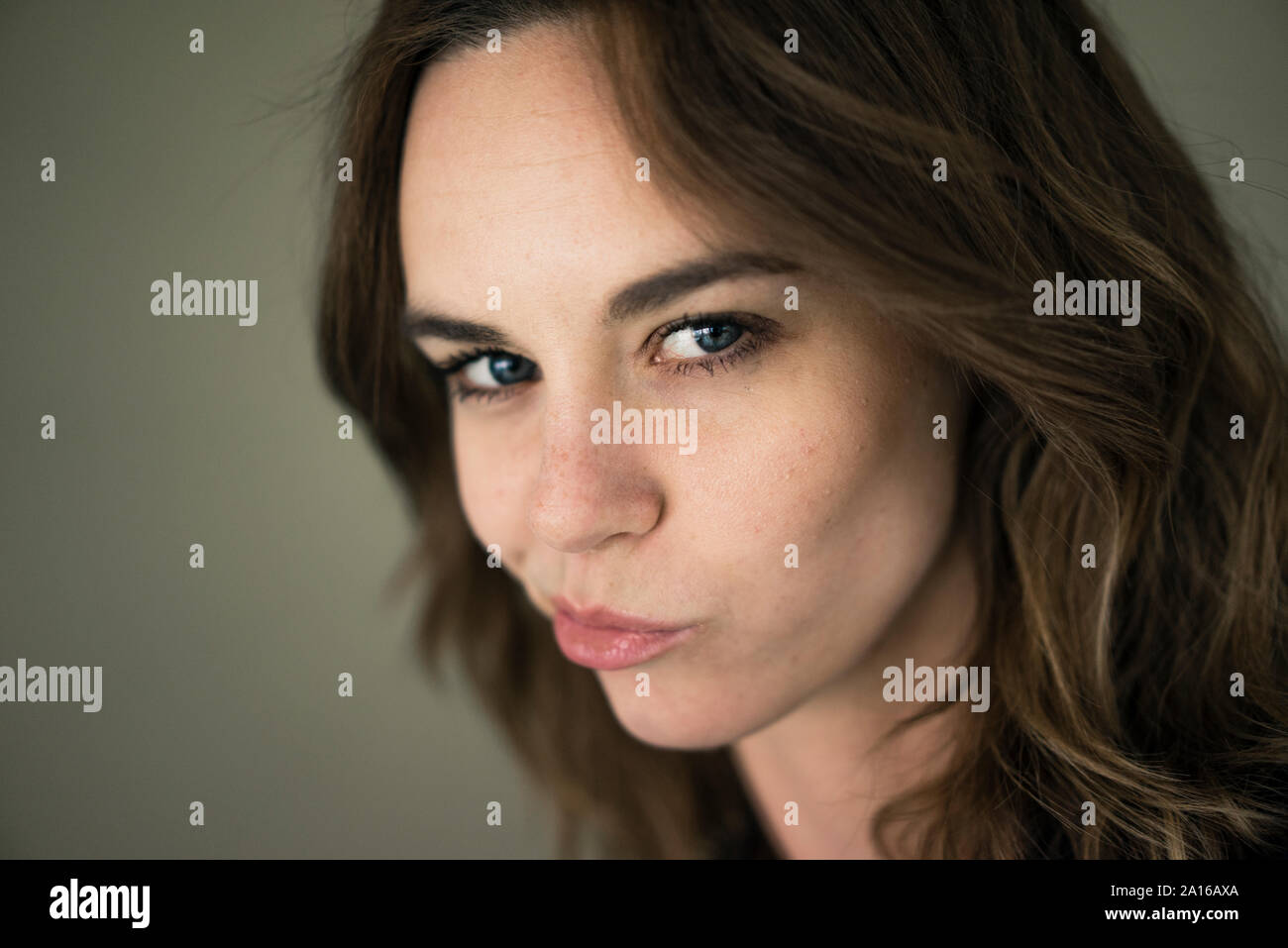 Portrait of young woman looking undecided Stock Photo - Alamy
