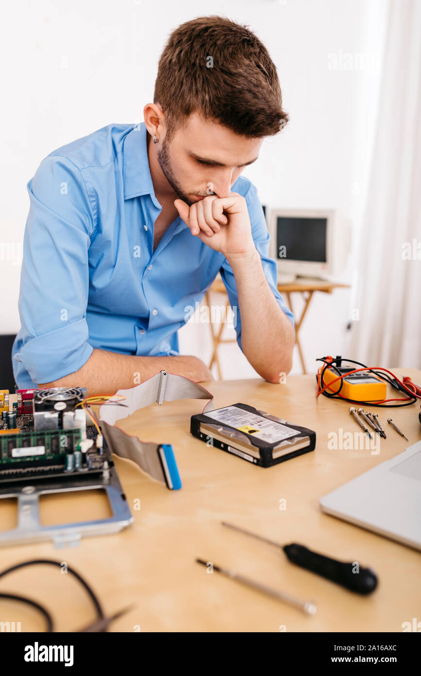 Technician repairing a desktop computer, thinking how to repair the ...