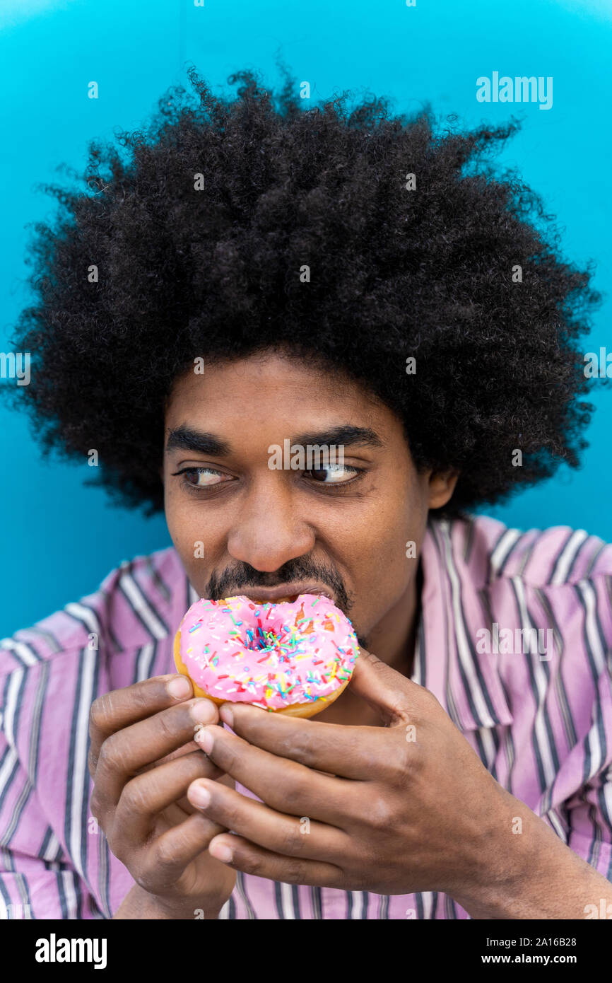 Young man eating donut Stock Photo - Alamy