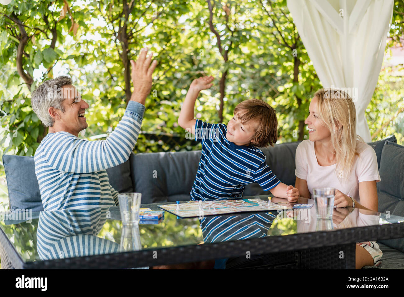 Happy father and son high fiving after winning a game on terrace Stock ...