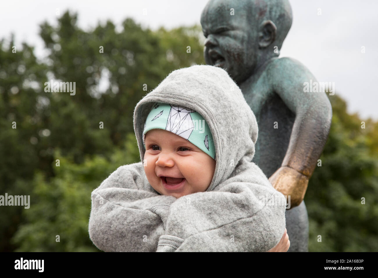 Laughing baby with statue of crying baby Stock Photo - Alamy