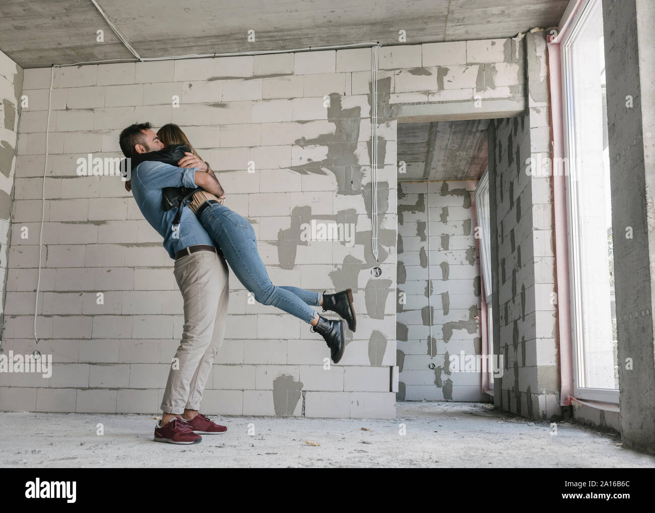 Happy couple of future owners at construction site Stock Photo - Alamy