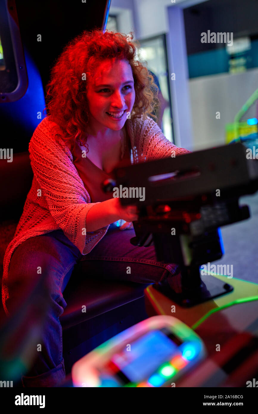 Woman having fun with a driving simulator in an amusement arcade Stock ...