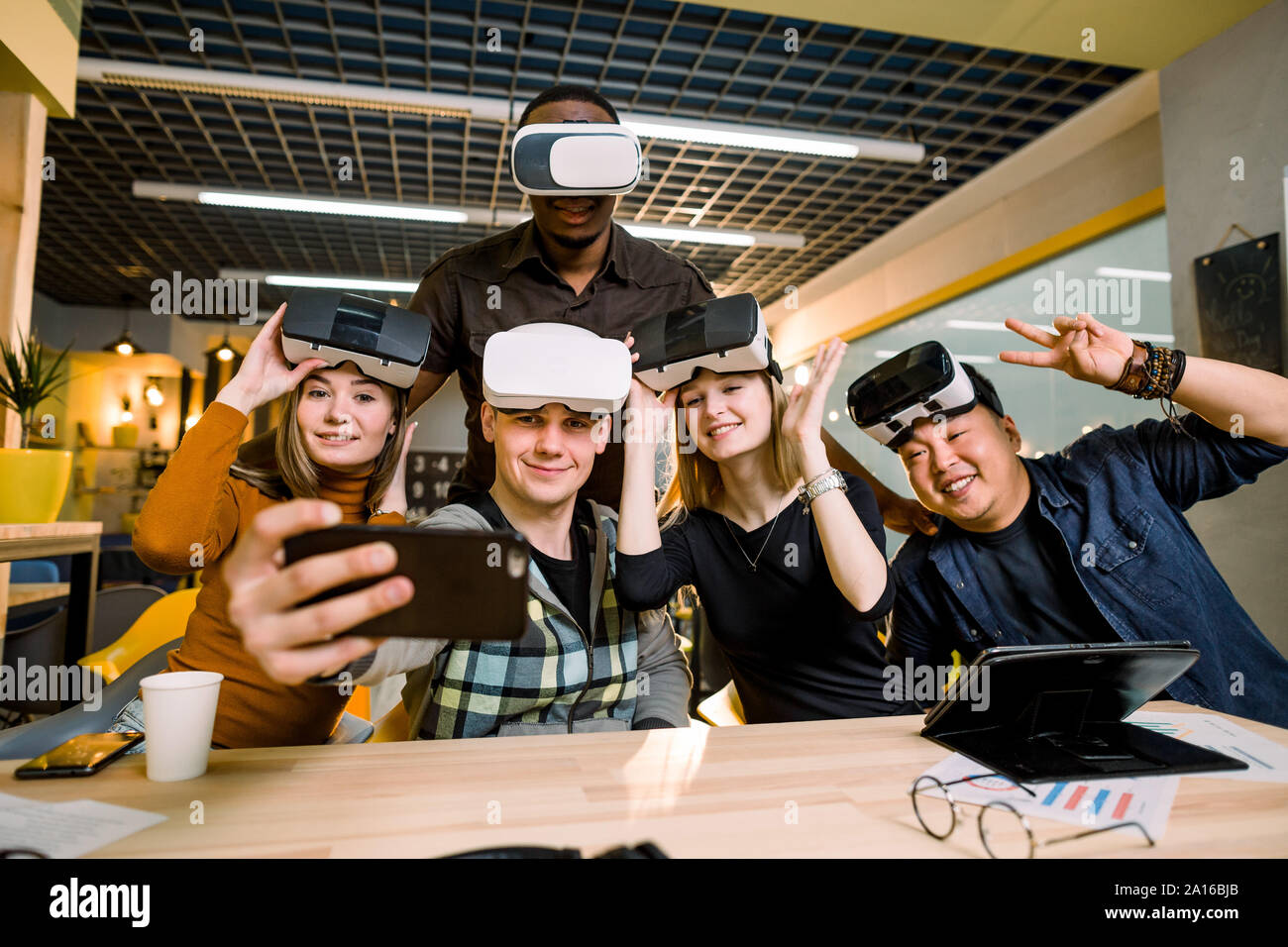 Young group of multiethnical people having fun with vr headset ...