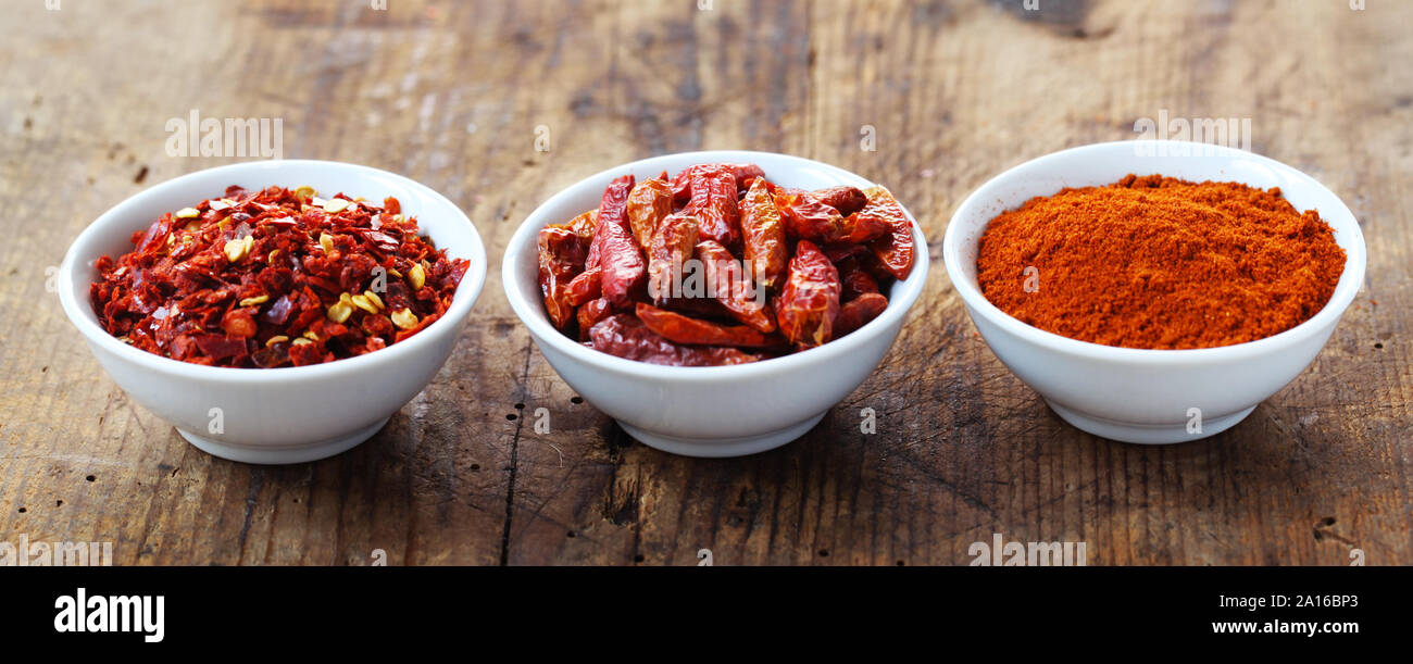 Various Forms Of Chilli In White Bowls On A Wooden Background Stock ...