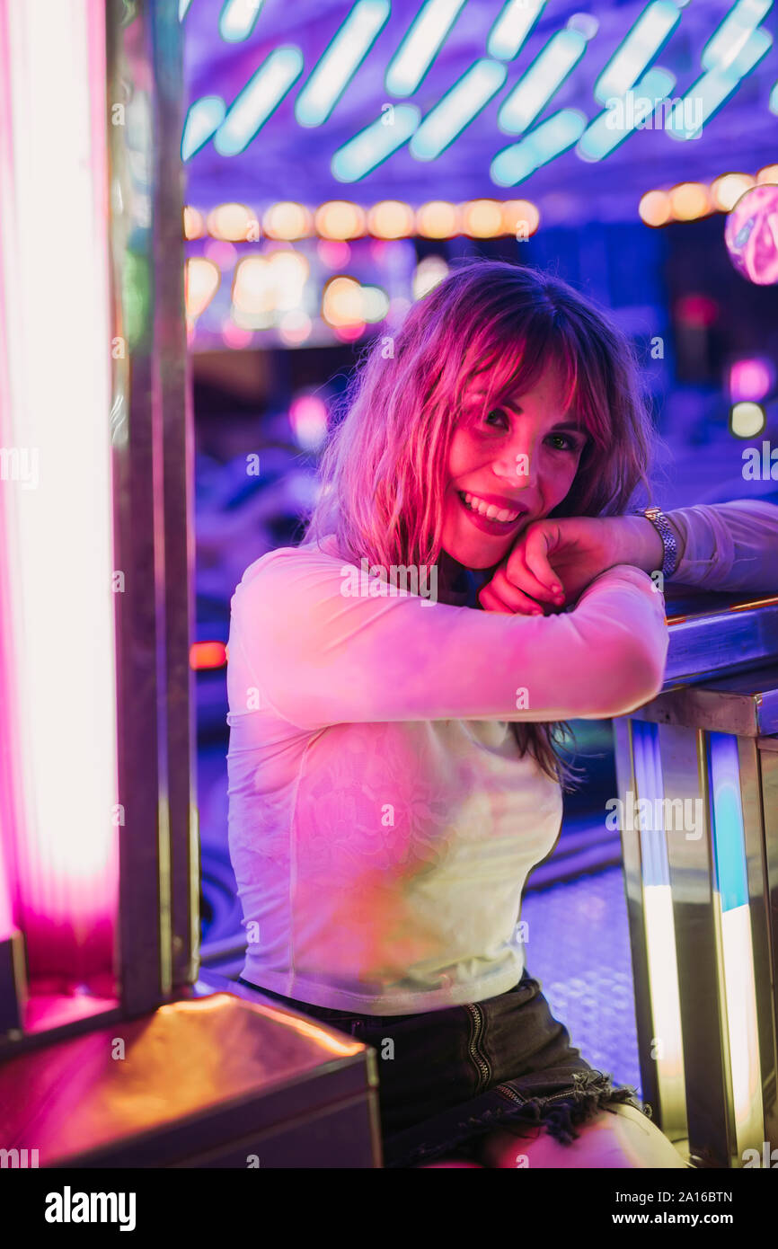 Portrait of a smiling young woman on a funfair at night Stock Photo - Alamy